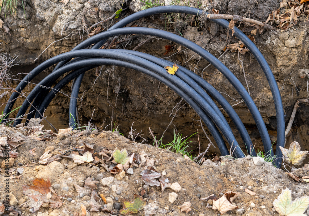 Black fiber optic cables for internet lying in the ground. Electricity ...
