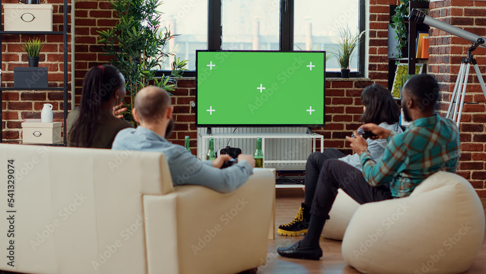 Happy friends playing video games on greenscreen background, enjoying ...
