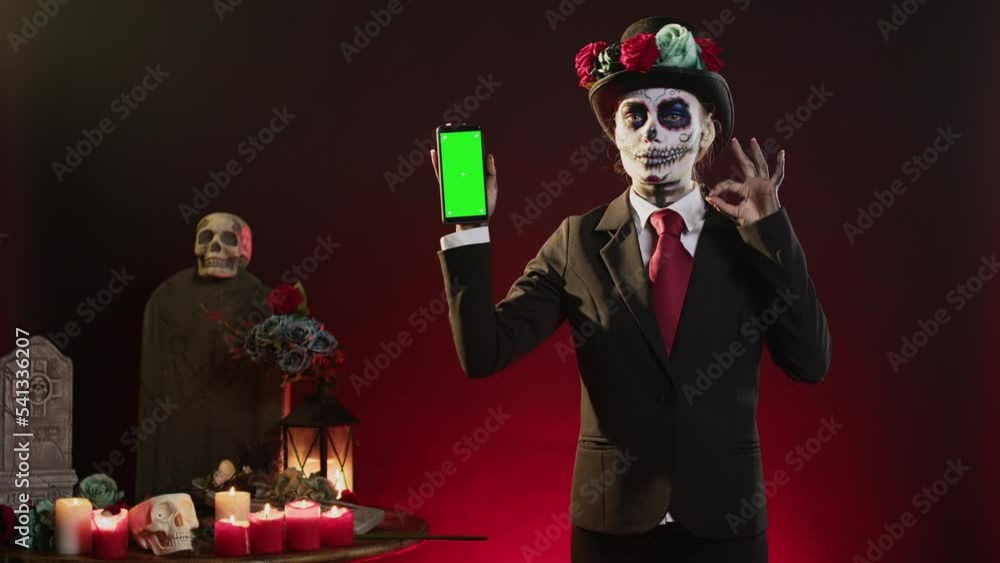 Holy goddess showing smartphone with greenscreen in studio, holding ...