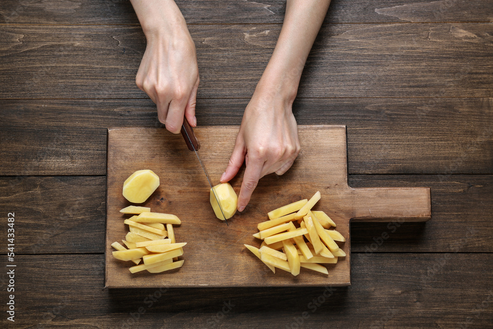 Woman cut potatoes at wooden table, top view Stock Photo | Adobe Stock