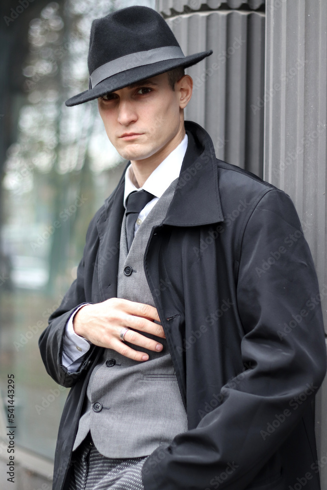 Men's photo session in a classic checkered suit and hat against the ...