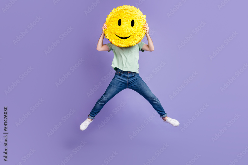 Full length photo of nice young man jumping hide face smile emoticon ...