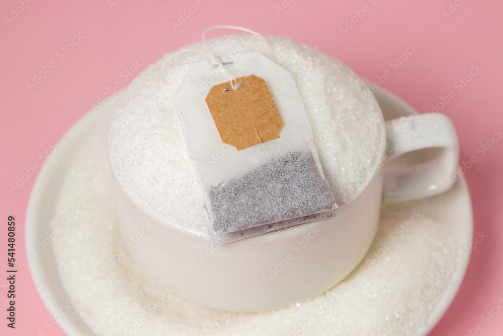 Tea with a lot of added sugar. Cup overflowing with sugar and tea bag ...