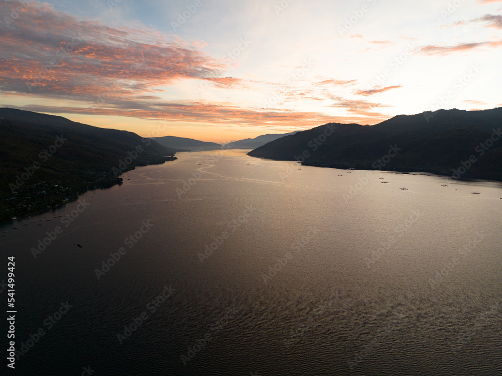A serene sunrise illuminates Kalabahi Bay surrounded by the island of ...