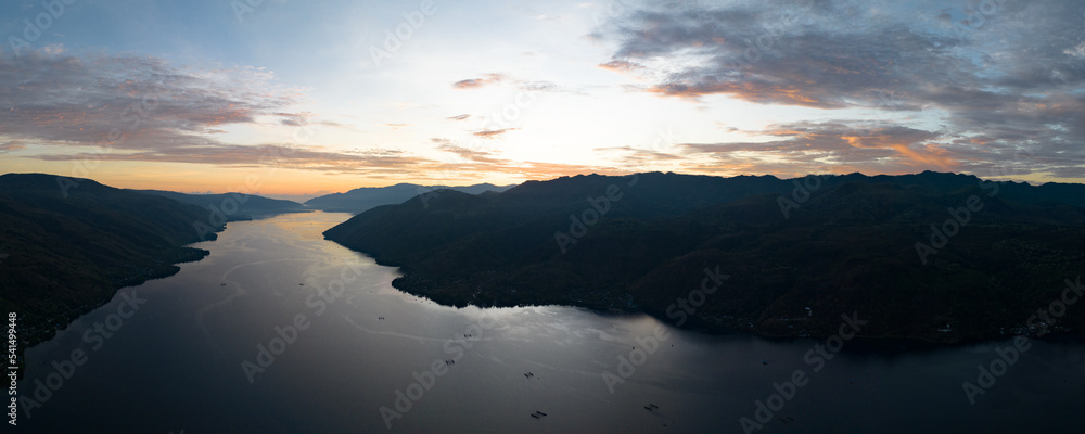 A serene sunrise illuminates Kalabahi Bay surrounded by the island of ...