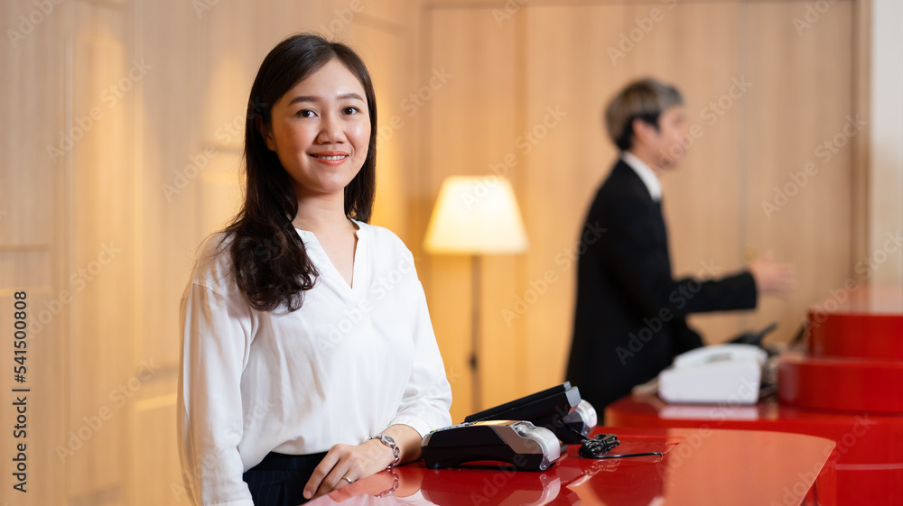 Friendly receptionist woman working at desk in hotel lobby. Leisure and ...