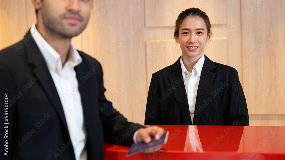 Friendly receptionist woman working at desk in hotel lobby. Leisure and ...