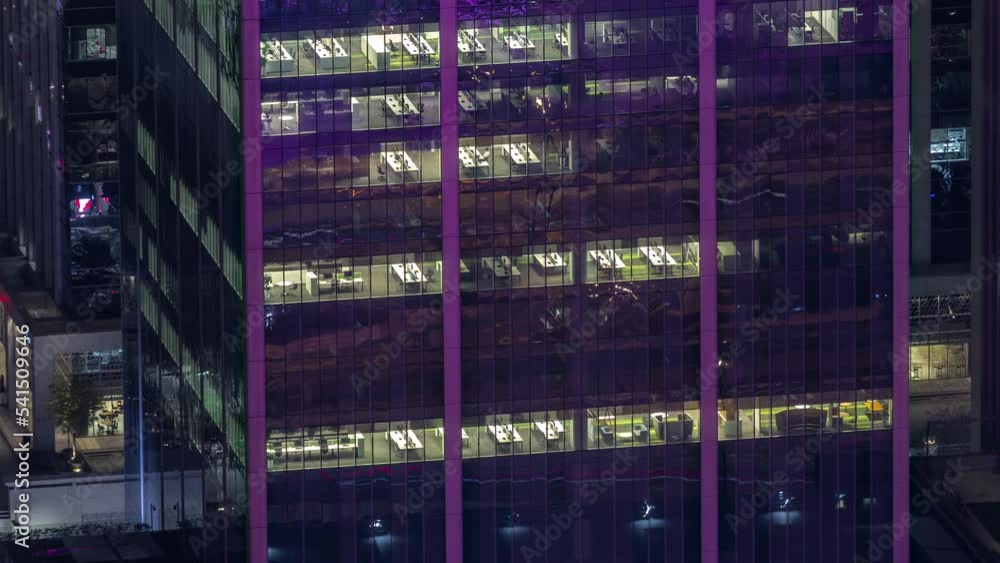 Illuminated panoramic windows in offices of a high class building at ...