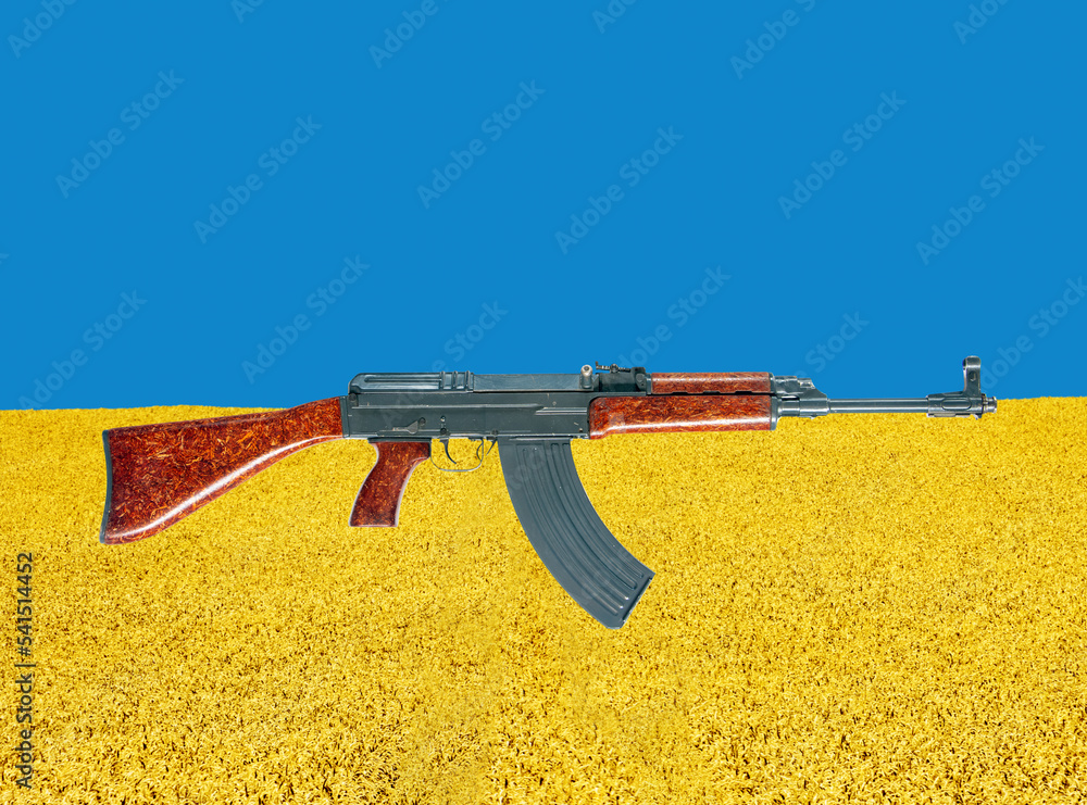 An old assault rifle on a background of a blue sky with yellow grain ...