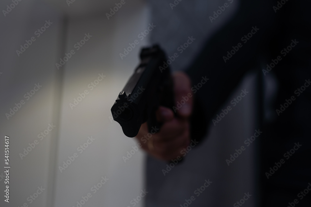 Male hand holding a gun on black background . A gun in a man's hand ...