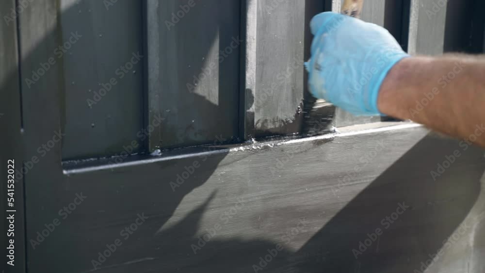 Renovation process of old eroded gate outside, male worker in ...