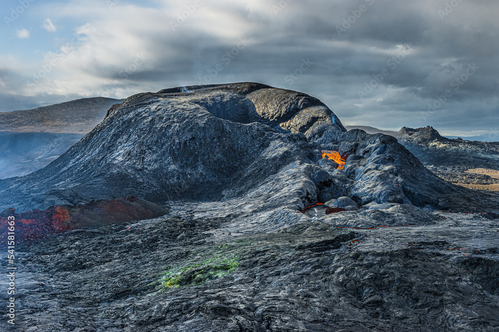 volcanic crater during the day with some lava in the crater mouth ...