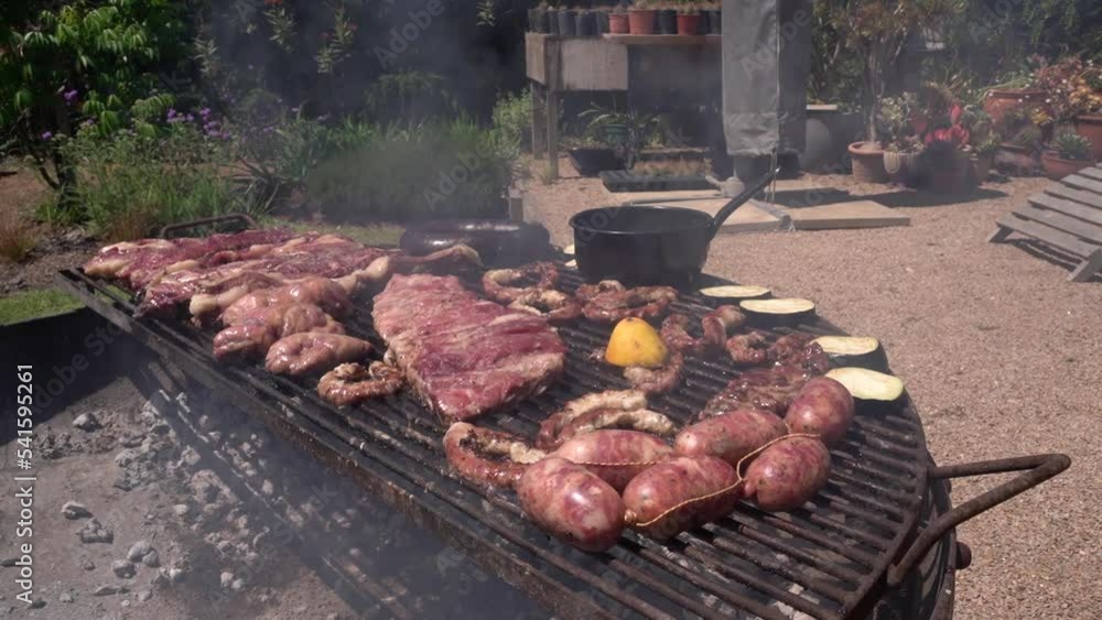 Barbecuing outdoors. View of a metal grill roasting beef, pork sausages ...