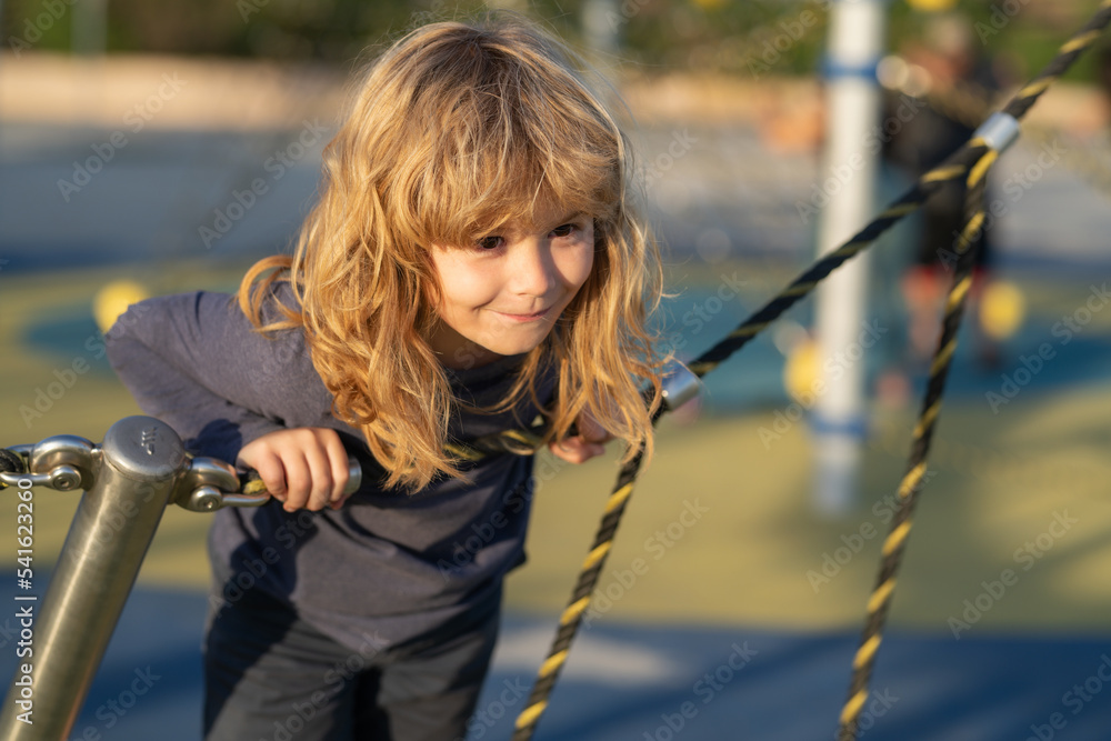 Kid boy climbing the net. Child boy playing at kids playground. Active ...
