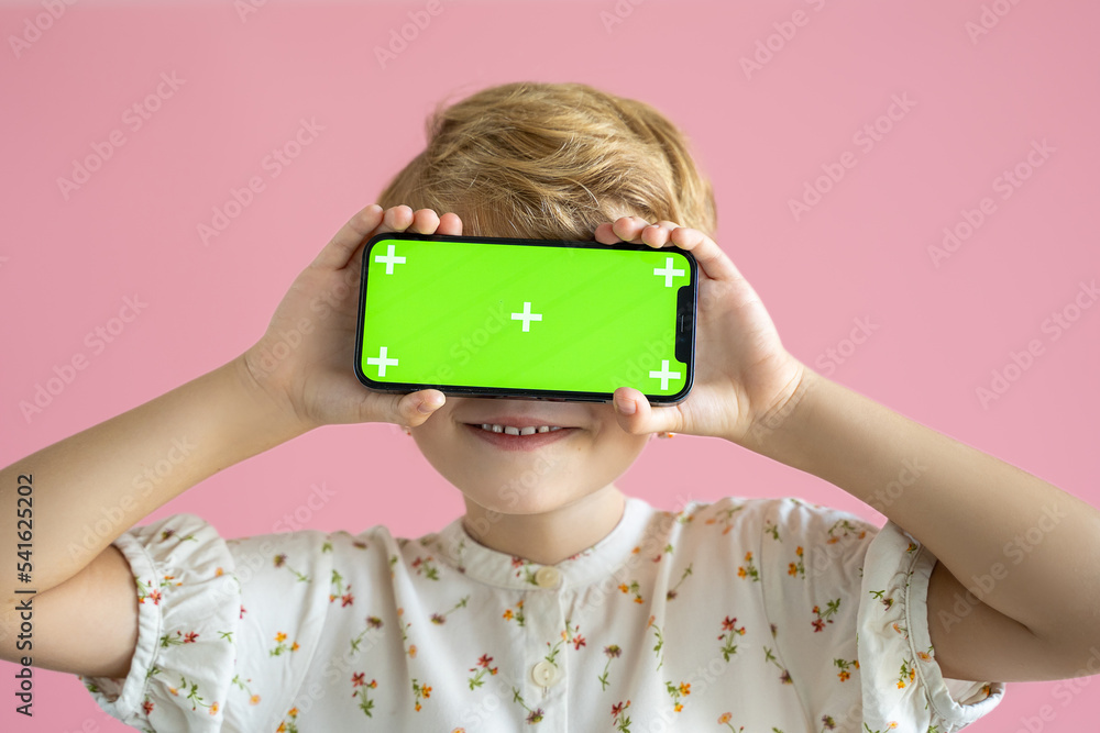 Little cute child girl show smartphone blank horizontal green screen ...