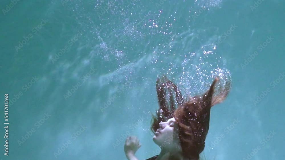 A pregnant girl swims and dives under the water. Medical training for a ...