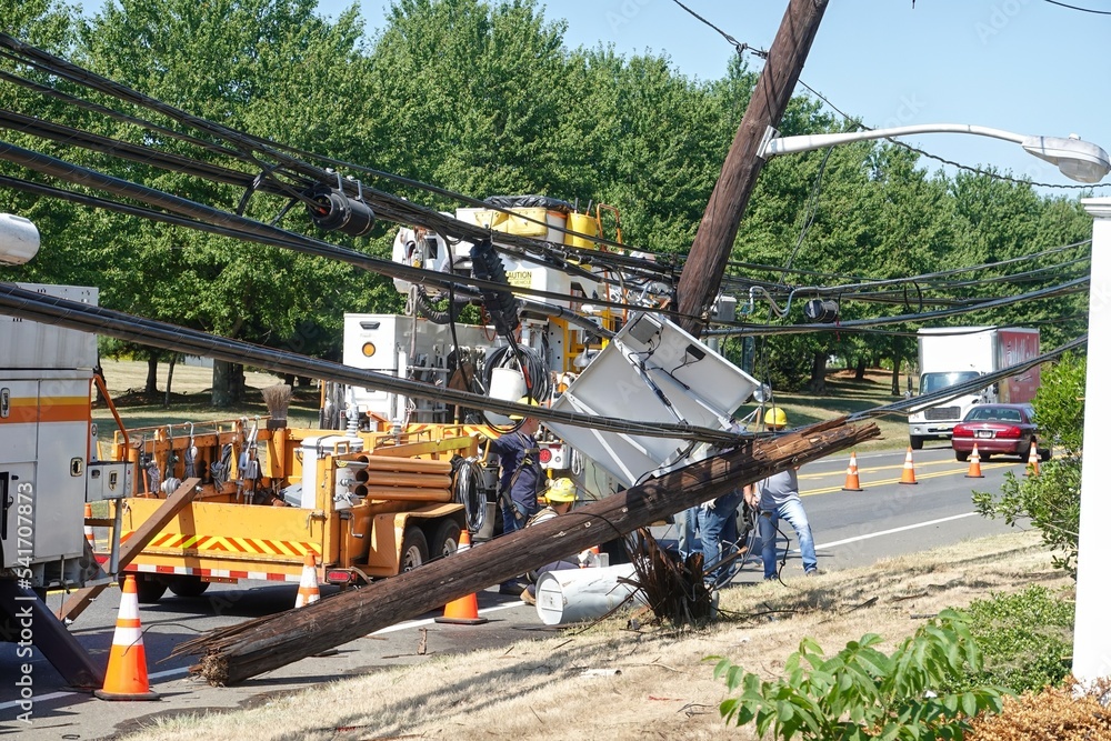 Electric utility repair crew on the scene of a broken wooden utility ...