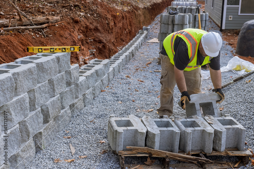 Construction site worker installing newly constructed large block ...