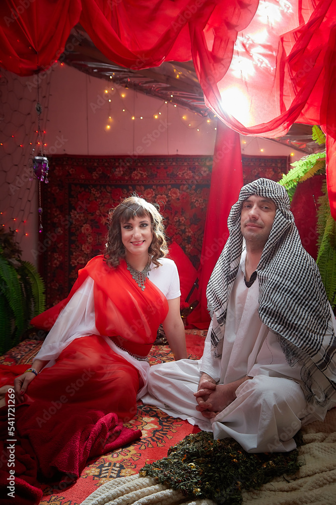 Portrait of young arabian muslim couple in traditional clothes in cozy ...