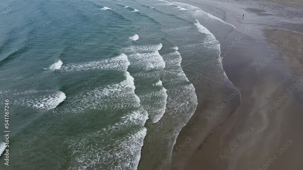 A deserted beach with wet sand and beautiful tidal waves. White sea ...