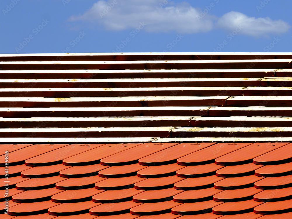 Beaver tail clay roof tile installation on sloped residential house ...