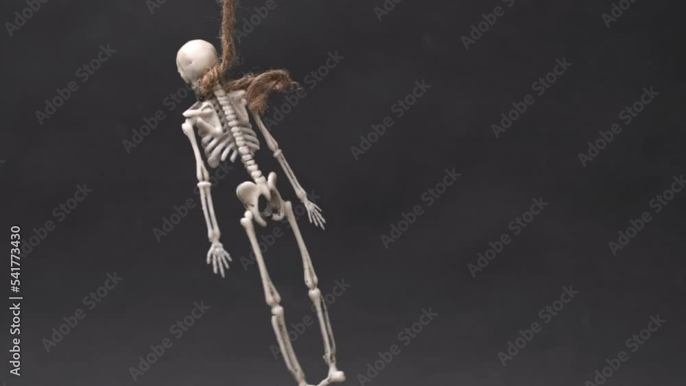 skeleton hanging on gallows over black background. Halloween video with ...
