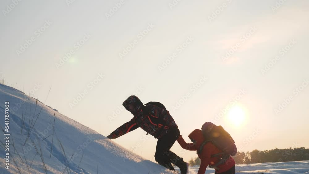 travelers climb snowy mountain sunset winter. hiking concept winter ...