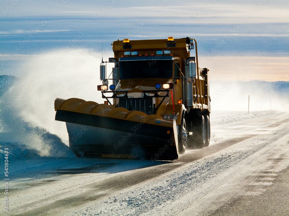 A snow plow clears the road from a winter storm Stock Photo | Adobe Stock