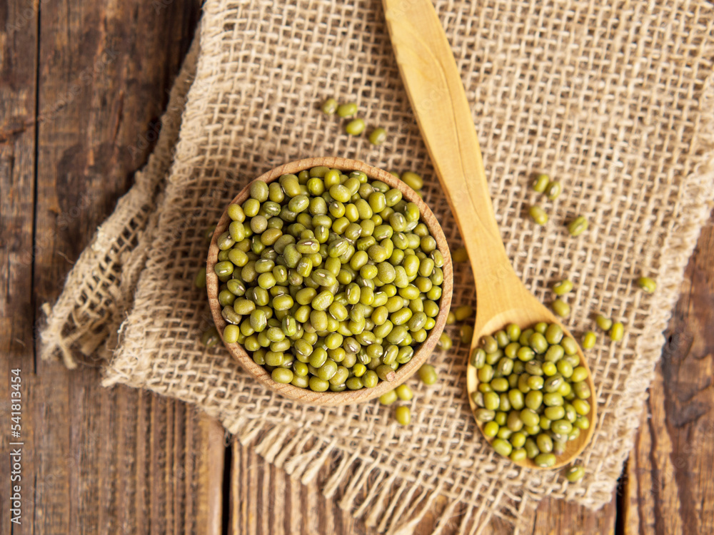 Close-up mung beans .Green mung beans in a wooden bowl on an old table ...