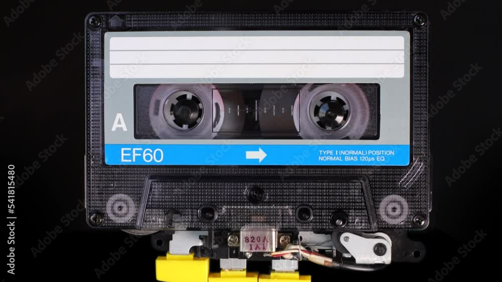 Audio cassette tape in use for sound recording in a tape recorder. A ...