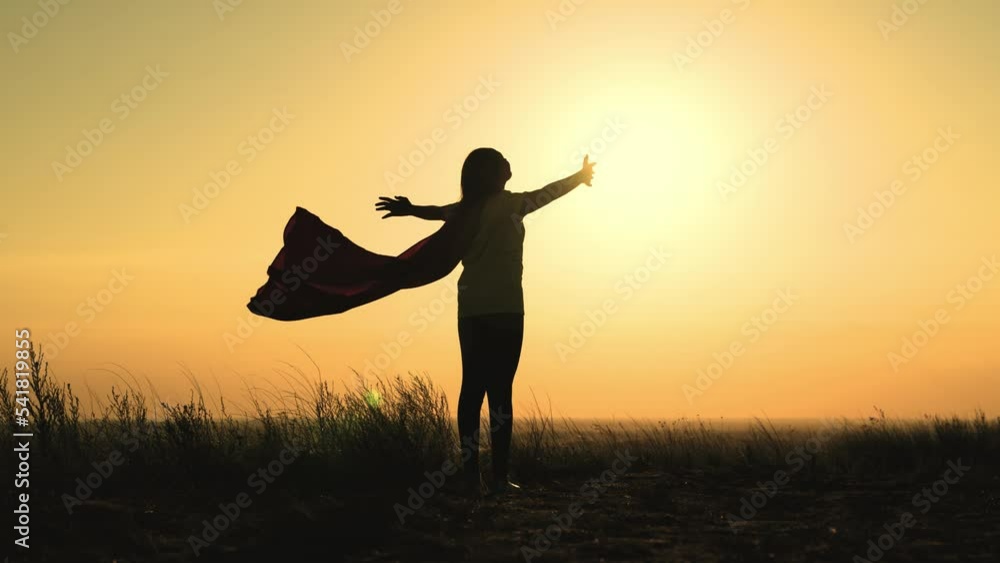 girl superhero with long hair red cape wind sunset. brave superhero ...