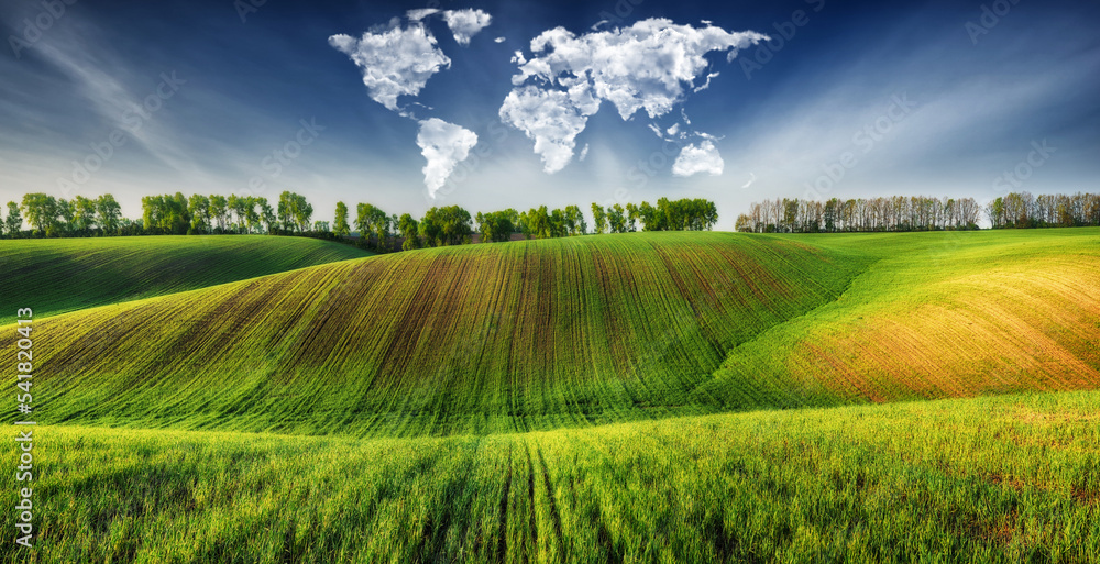 clouds in the form of a world map over a green field. Travel and ...