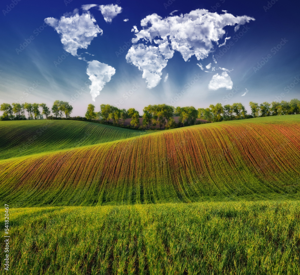 clouds in the form of a world map over a green field. Travel and ...