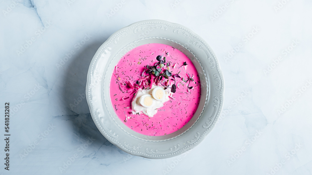 Top view of a delicious pink creamy beetroot soup with sliced eggs in ...