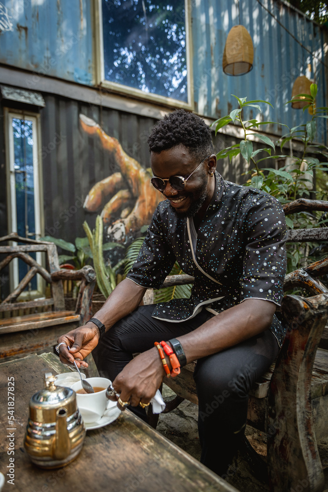 a man pouring tea into a tea cup Stock Photo | Adobe Stock