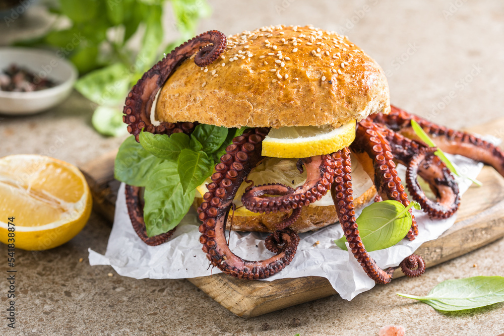 Big burger with octopus and lemon. Large sandwich stuffed with seafood ...