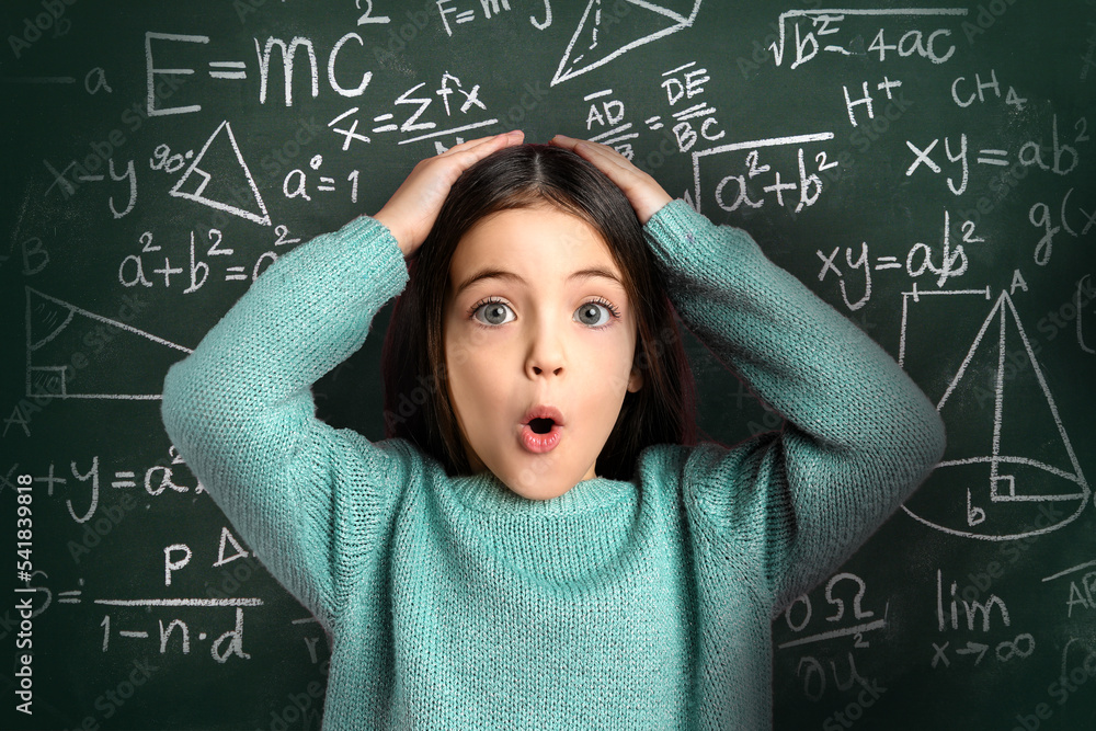 Emotional little girl near chalkboard with different formulas Stock ...