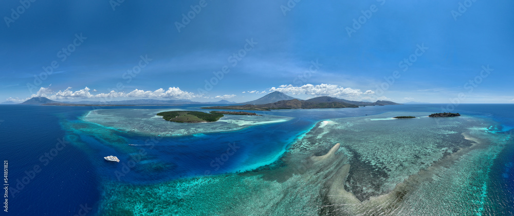 A beautiful coral reef fringes a channel in the Lesser Sunda Islands of ...