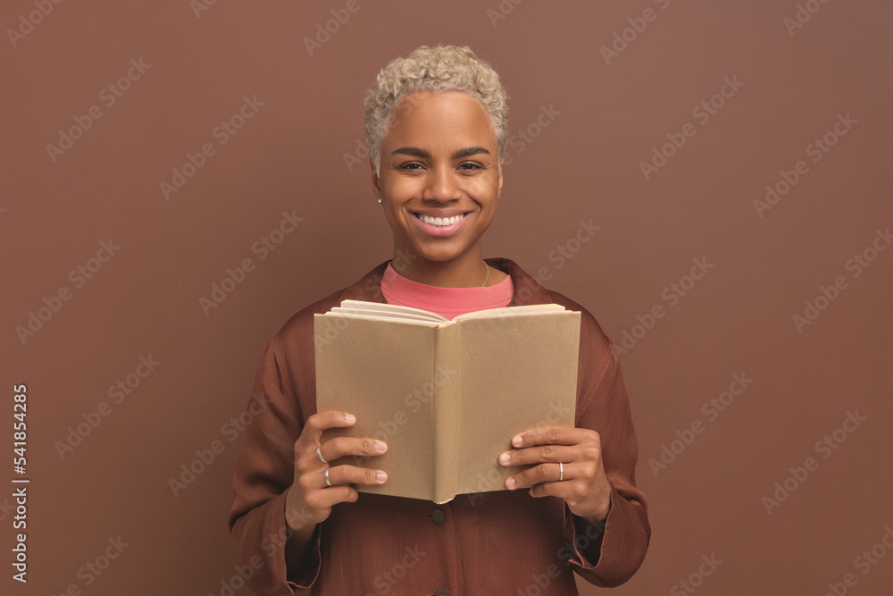 Young happy beautiful African American woman with open book looks at ...