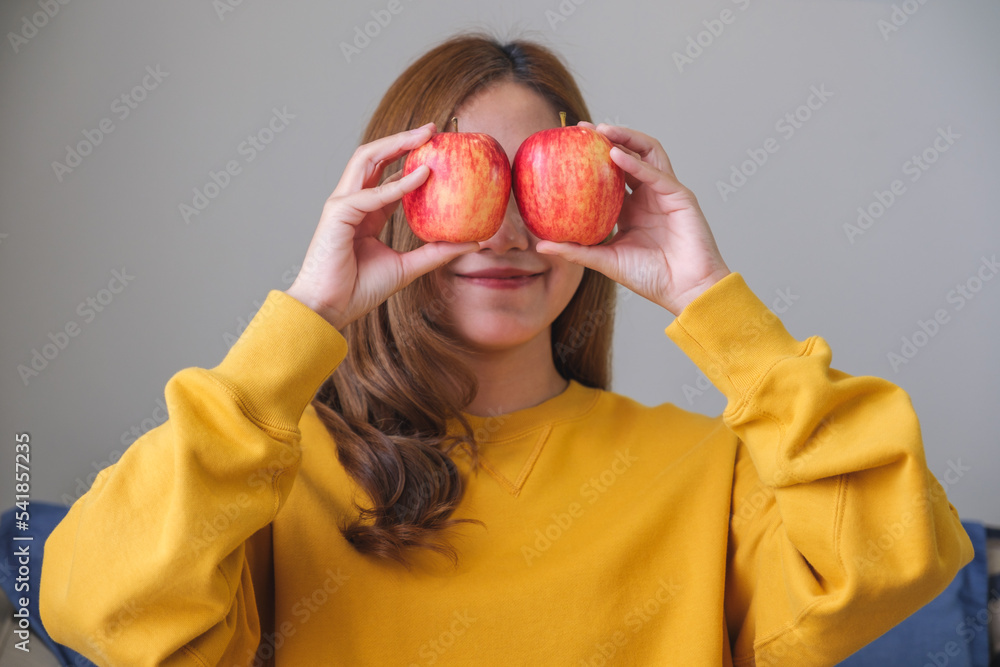 A beautiful young woman holding and covering eyes with an apple Stock ...