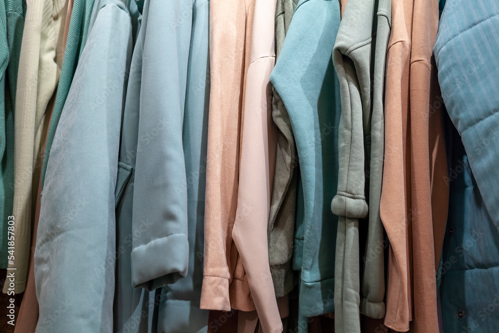 Colorful women's dresses, jackets, trousers and other clothes on ...