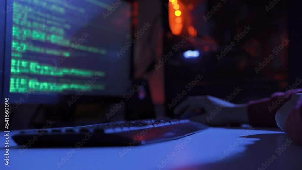 Male hacker doing cyber attack in a dark gloomy room with screen ...