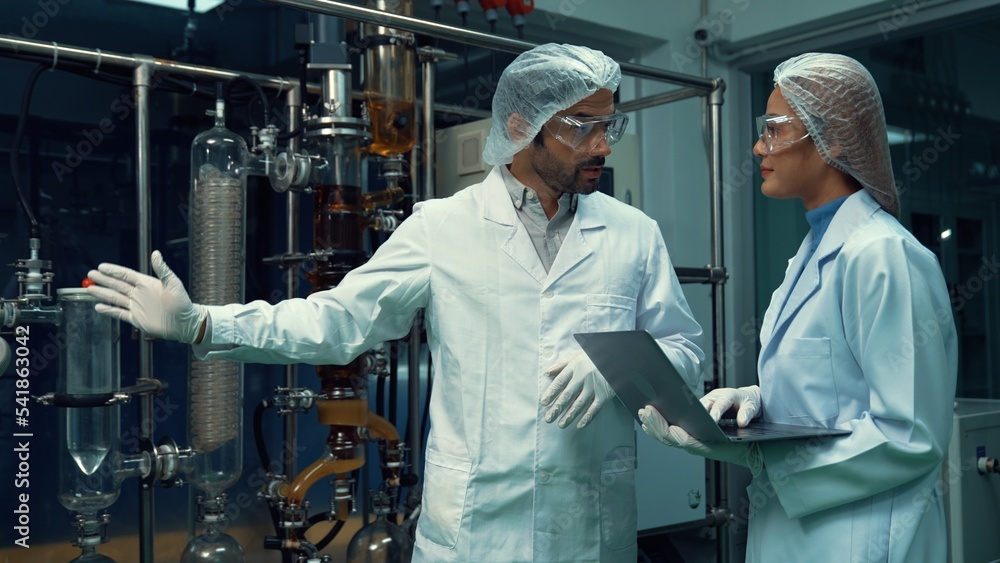 Two scientist in professional uniform working in laboratory for ...