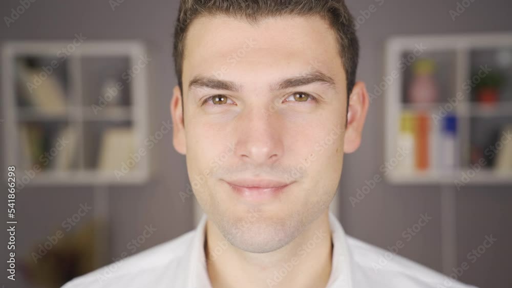 Man looking at camera nods affirmatively. The man glances up and ...