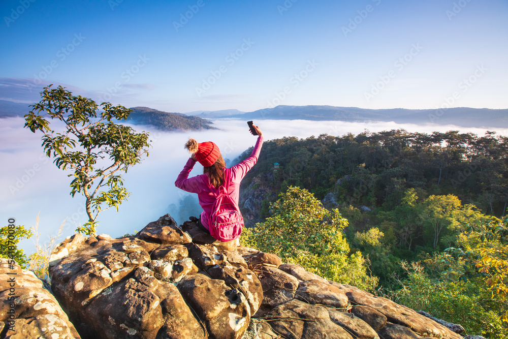 Young woman in red jacket hiking on Pha Muak mountain, border of ...