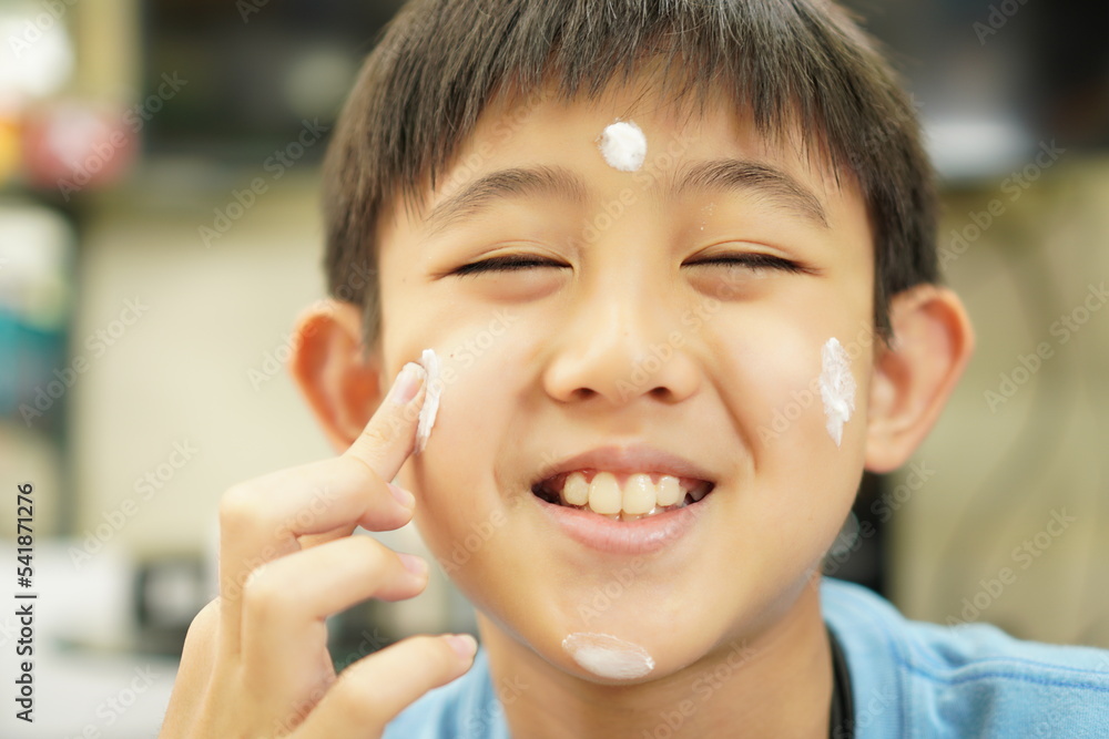 Skin care: The picture shows a kid applying The picture shows a young ...