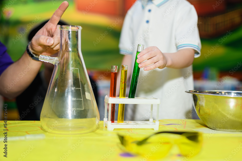 Teacher with a student at a chemistry lesson put an experiment ...