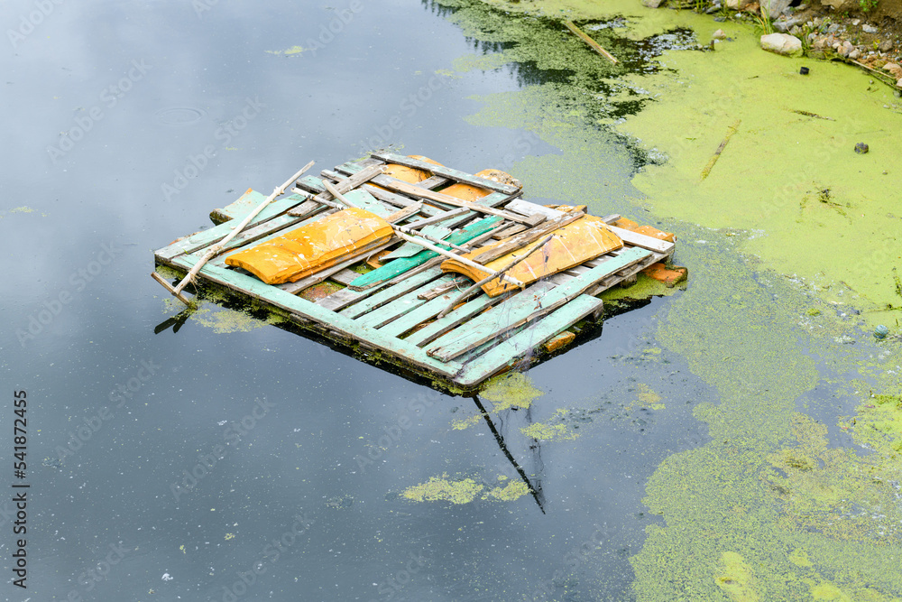 Garbage and blooming green water. Device, raft for cleaning dirt in the ...