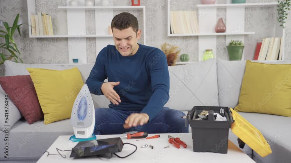 Clumsy young man trying to repair his home appliance. Inexperienced ...