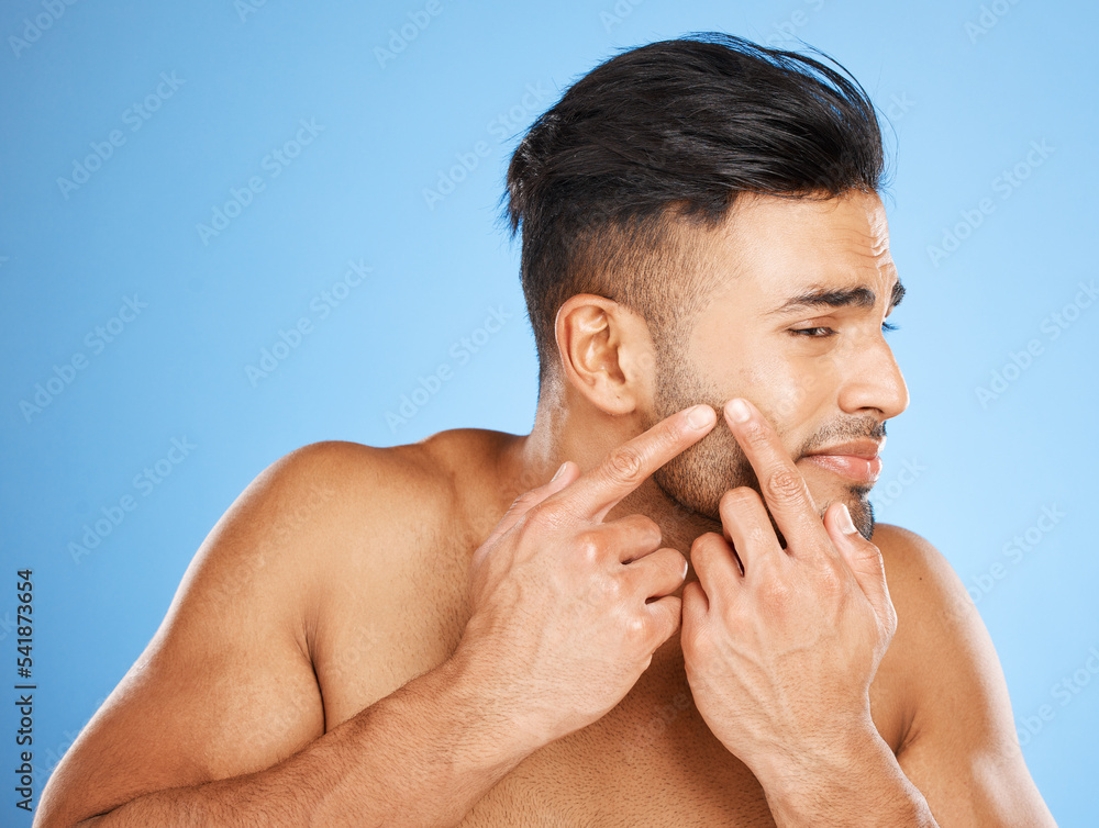 Health, skincare and man popping acne in face with blue background ...